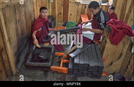 Monks making handmade paper scriptures and woodblock prints inside the ...
