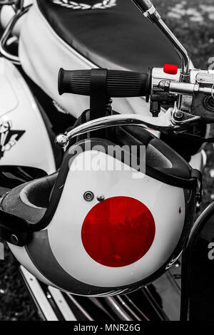 Red motorcycle with a helmet hanging off the handlebars shot from the ...