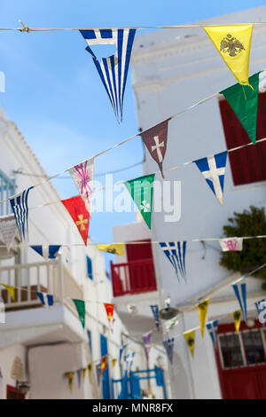 Mykonos alley and greek flag on national holiday Stock Photo - Alamy
