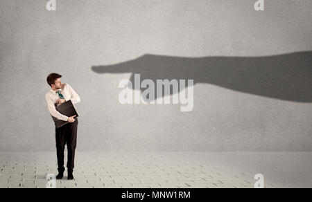 Business person looking at huge shadow hand pointing at him concept on ...