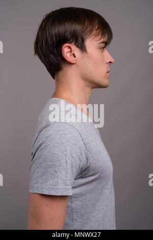 Young handsome man ready for gym against gray background Stock Photo ...