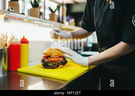 Chef prepares burger, fast food cooking. Hamburger preparation process ...