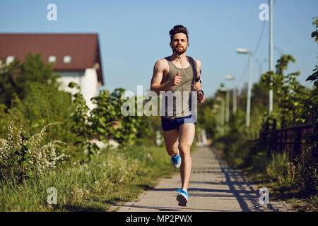 A young male runner jogs in the park Stock Photo - Alamy