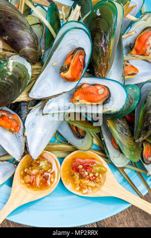 Steaming mussel With delicious sauce on dish with wood table seafood ...