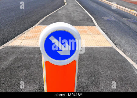Traffic bollard sign in the middle of the road. Arrow pointing left in ...