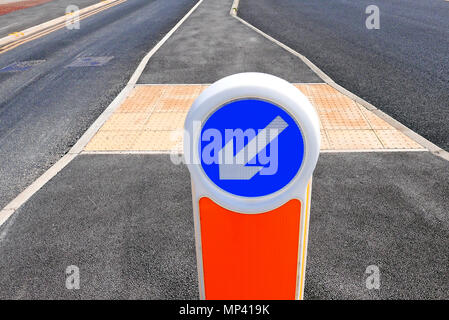 Keep left traffic bollard in the centre of new road Stock Photo - Alamy