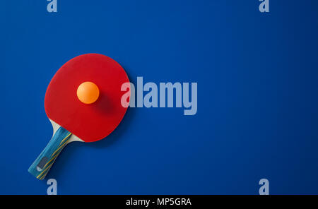 Red tennis racket lies on a blue table with a yellow ball Stock Photo ...