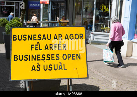 A sign saying that Business Open As Usual stands in a narrow City of ...