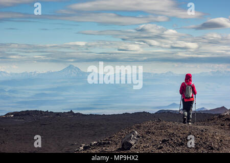 man standing on volcanic slag with view on snowy volcanoes Stock Photo ...