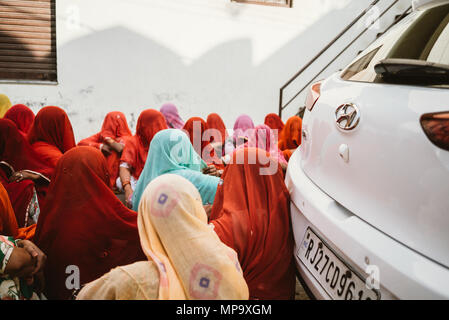 A group of colorfully dressed women mourning a death of a person in ...