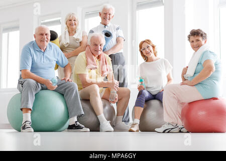 Elderly people relax on fitness equipment in Wenfeng Park, with a group ...