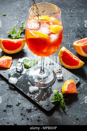 Cocktail drink on stone board. Alcoholic beverage with grapefruit and ...