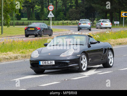 Porsche open top sports car with child in rear in child seat on Western ...