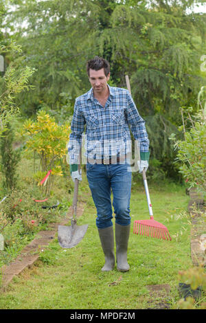 Man carrying garden tools , rake , spade and besom broom . 1935 Stock ...