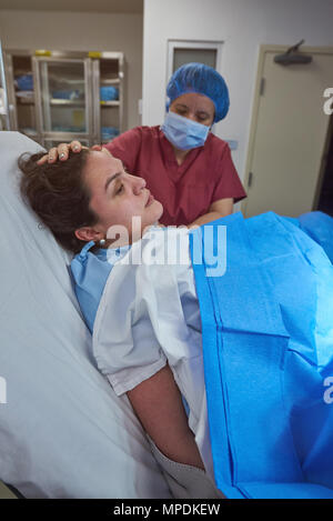 Tired woman surgeon in operating room after major surgery feeling ...