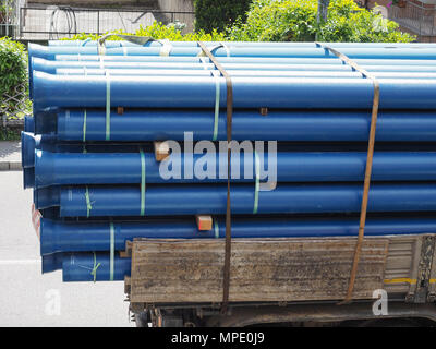 large blue pipes being transported on a truck Stock Photo - Alamy