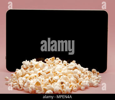 A tablet on a blue background with popcorn and headphones Stock Photo ...