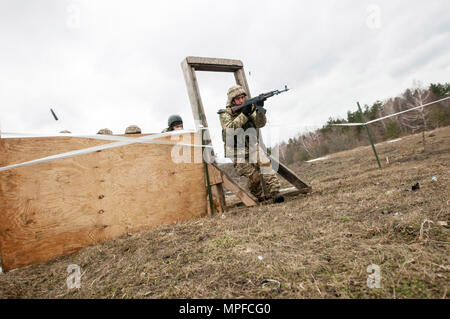 A Ukrainian combat training center engineer kicks in a door after using ...