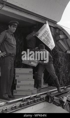 MEN LOADING PACKAGES OFF OF A PLANE Stock Photo - Alamy