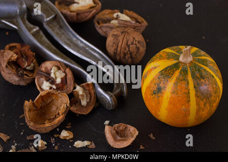 Small pumpkin and walnuts on a rustic wooden board Stock Photo - Alamy