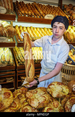 Teenage boy making bread in the kitchen at home wearing an apron Stock ...