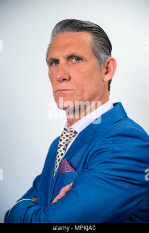 A vertical shot of a handsome Caucasian Spanish man with tattoos posing ...