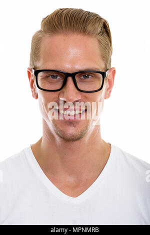 Young happy white man wearing earphones smiling and using cellphone in ...