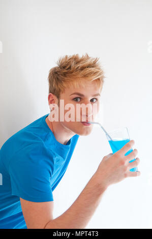 Young man drinking blue soft drink Stock Photo - Alamy