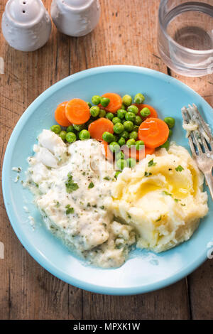 grilled cod with mashed potato, carrots, slice tomato and mushy pea ...
