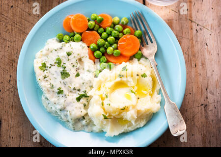 Cod fillet in parsley sauce with mash, peas and carrots Stock Photo - Alamy