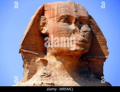 A statue of an ancient lion-sphinx stands in front of a pine tree in ...