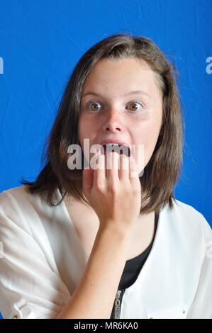 Scared teen on blue background Stock Photo - Alamy