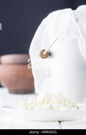 Fresh cottage cheese on the metal plate with bread on the white wooden ...