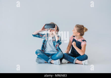 Child with virtual reality headset sitting behind natrue outdoors at ...