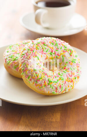 Delicious donuts with icing on table on bright background Stock Photo ...