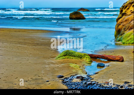 Small waves in the Pacific Ocean crashing over volcanic rock ...