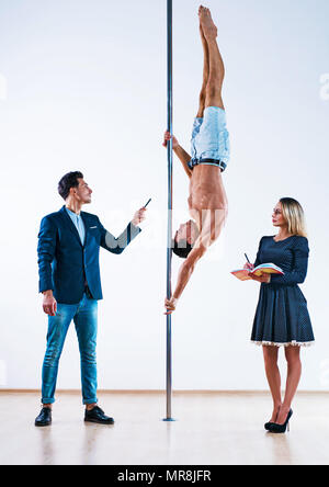 Young man and woman pole dancers. Man expressing feelings and giving ...