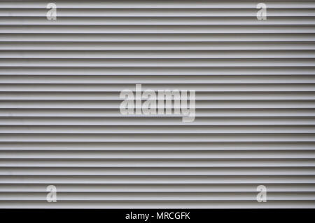 modern closed garage with metal door on street of city at night time ...