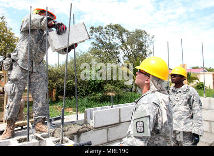 U.S. Soldiers from the 808th Engineer Company are laying cinder blocks ...