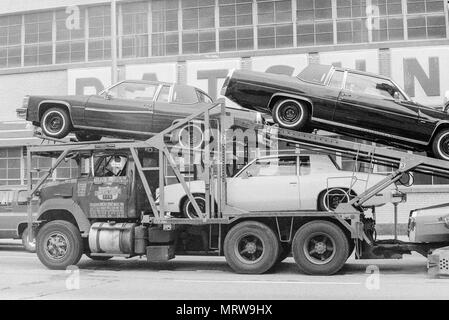 A car transporter with new Cadillac Coupe DeVille cars being loaded in ...