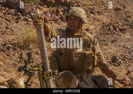 A Marine drops a 60mm mortar into an M224 mortar system during a live ...