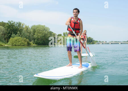 silhouette of perfect couple engage standup paddle boarding Stock Photo ...