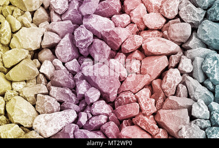 Assorted rocks of different sizes and colors embedded in concrete on an ...