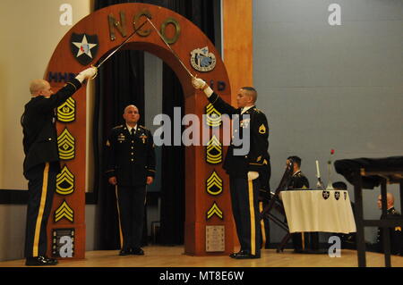 A newly promoted NCO walks through the NCO arch and crossed sabers ...