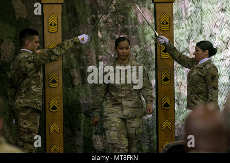 A newly promoted NCO walks through the NCO arch and crossed sabers ...