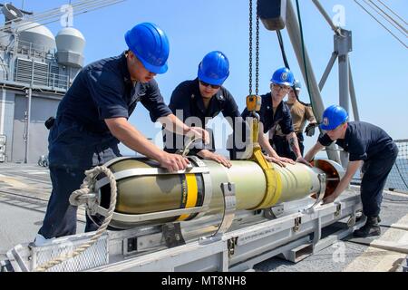 Sailors secure a Mark 46 Mod 5A torpedo on the flight deck aboard USS ...