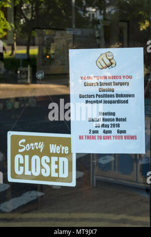 A poster in a shop window advertising 50% discounts as the store is ...