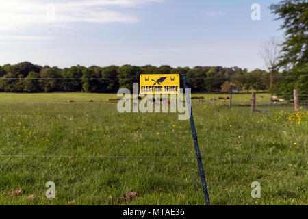 An electric fence in a field. Electrified fence, electric barrier ...