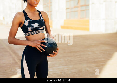 cropped shot of woman in sportswear holding baseball bat and ball while ...