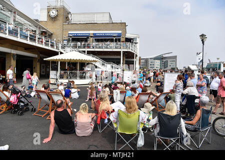 A busy and crowded Mermaid Quay in Cardiff, Bay, Wales, UK on a bank ...